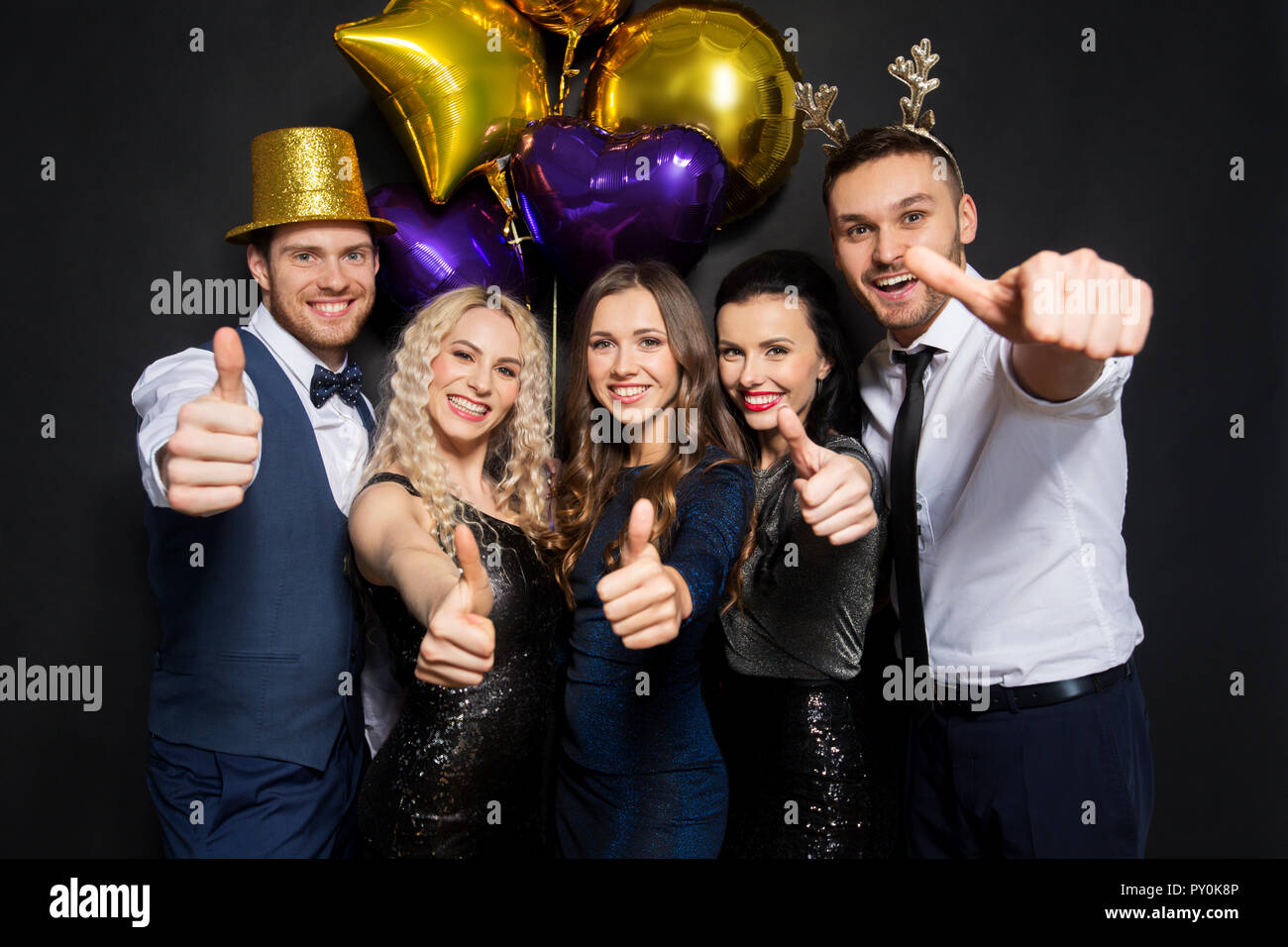 friends at christmas party showing thumbs up Stock Photo - Alamy