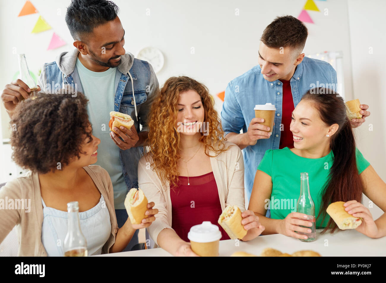 happy friends or team eating at office party Stock Photo - Alamy