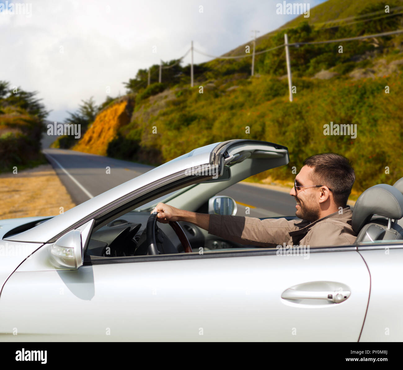 man driving convertible car over big sur hills Stock Photo - Alamy