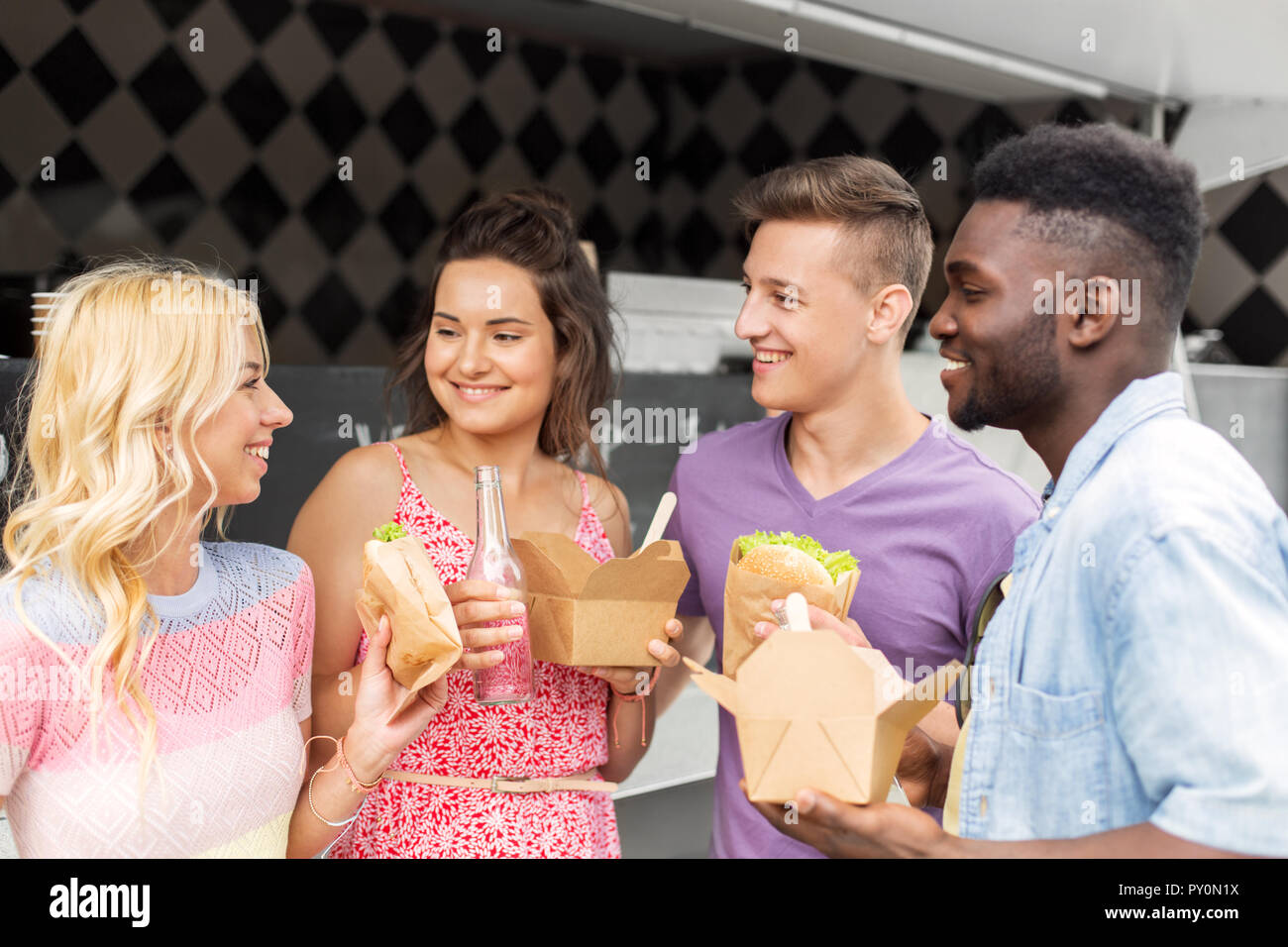 happy friends with drinks eating at food truck Stock Photo - Alamy
