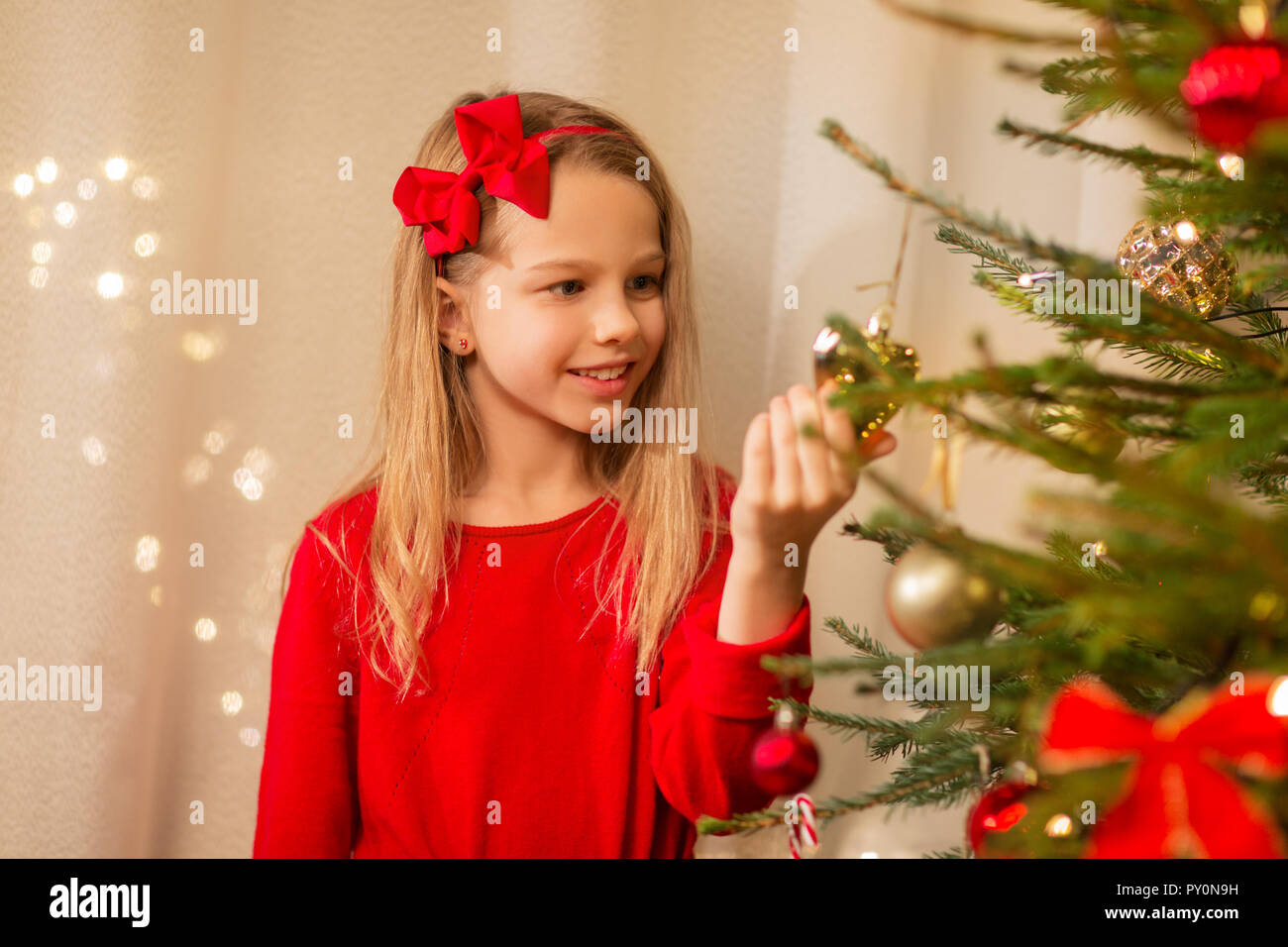 happy girl in red decorating christmas tree Stock Photo - Alamy