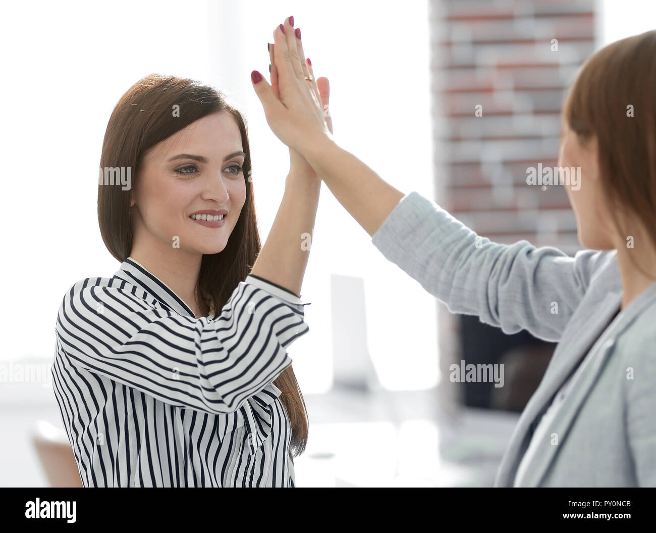 two young co-workers giving each other a high five Stock Photo - Alamy
