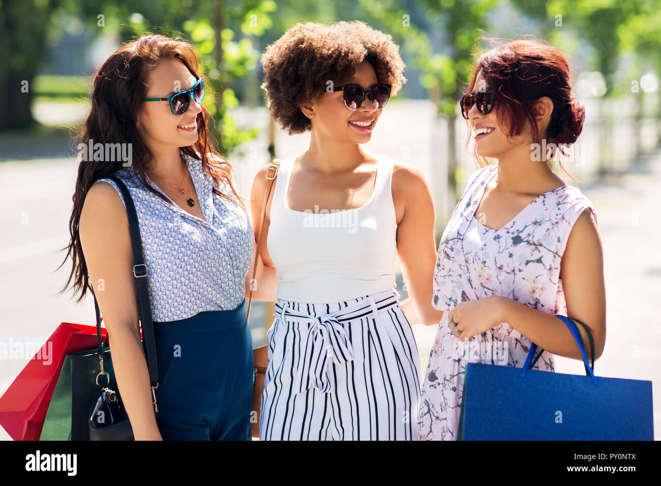 happy women with shopping bags in city Stock Photo - Alamy