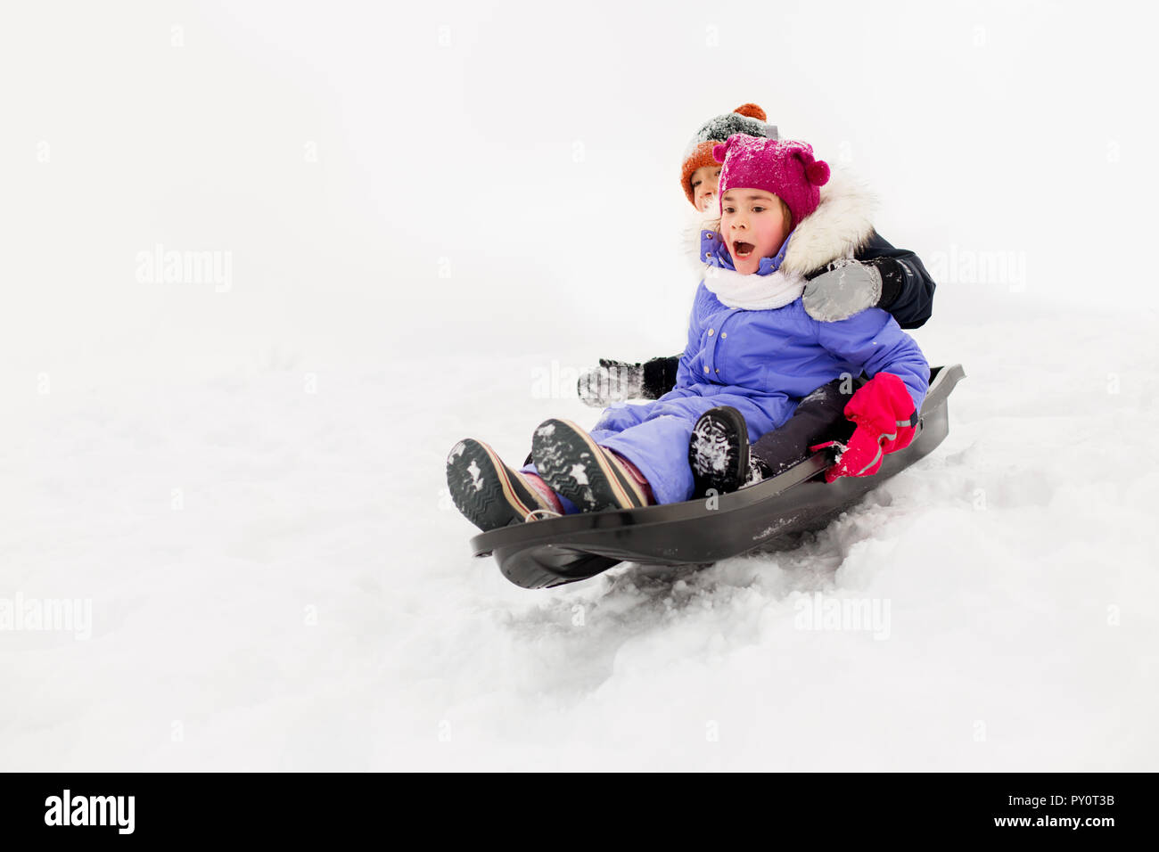 kids sliding on sled down snow hill in winter Stock Photo - Alamy