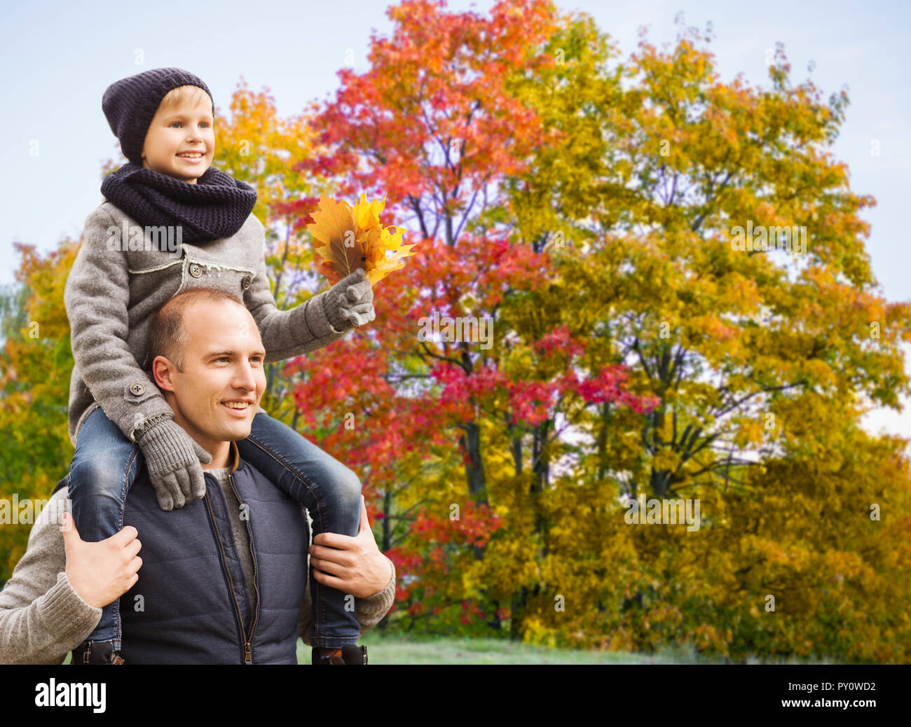 happy father carrying son with autumn maple leaves Stock Photo - Alamy