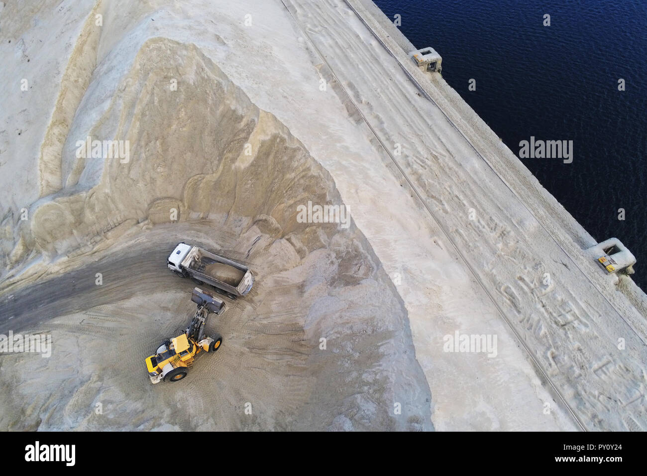 Big heavy wheel loader loading sand into dump truck in sand pit. Heavy ...
