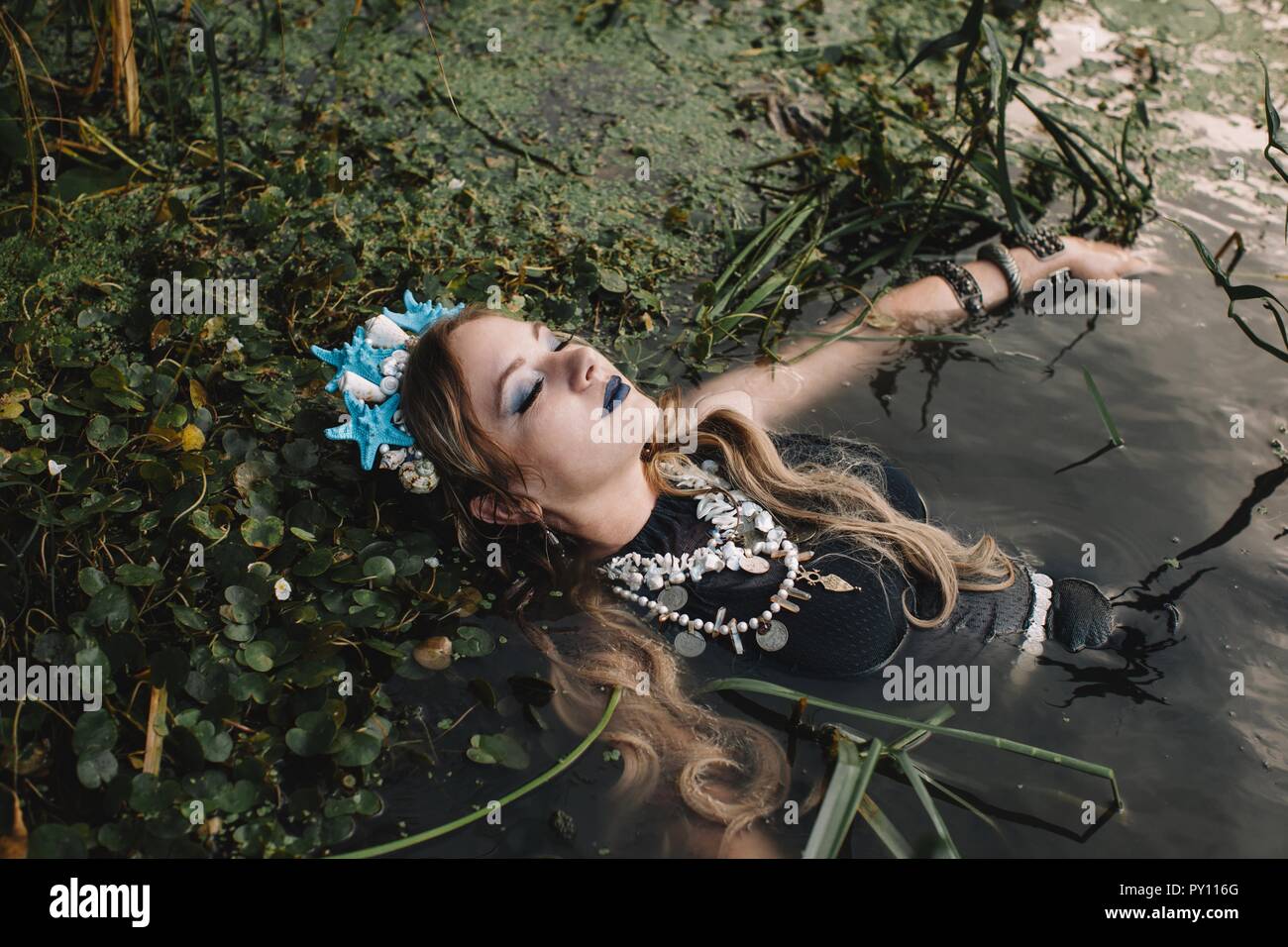 Portrait of a boho woman lying in lake, Russia Stock Photo - Alamy