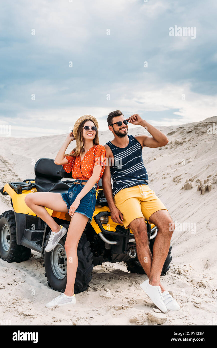 stylish young couple leaning back on ATV in desert Stock Photo - Alamy