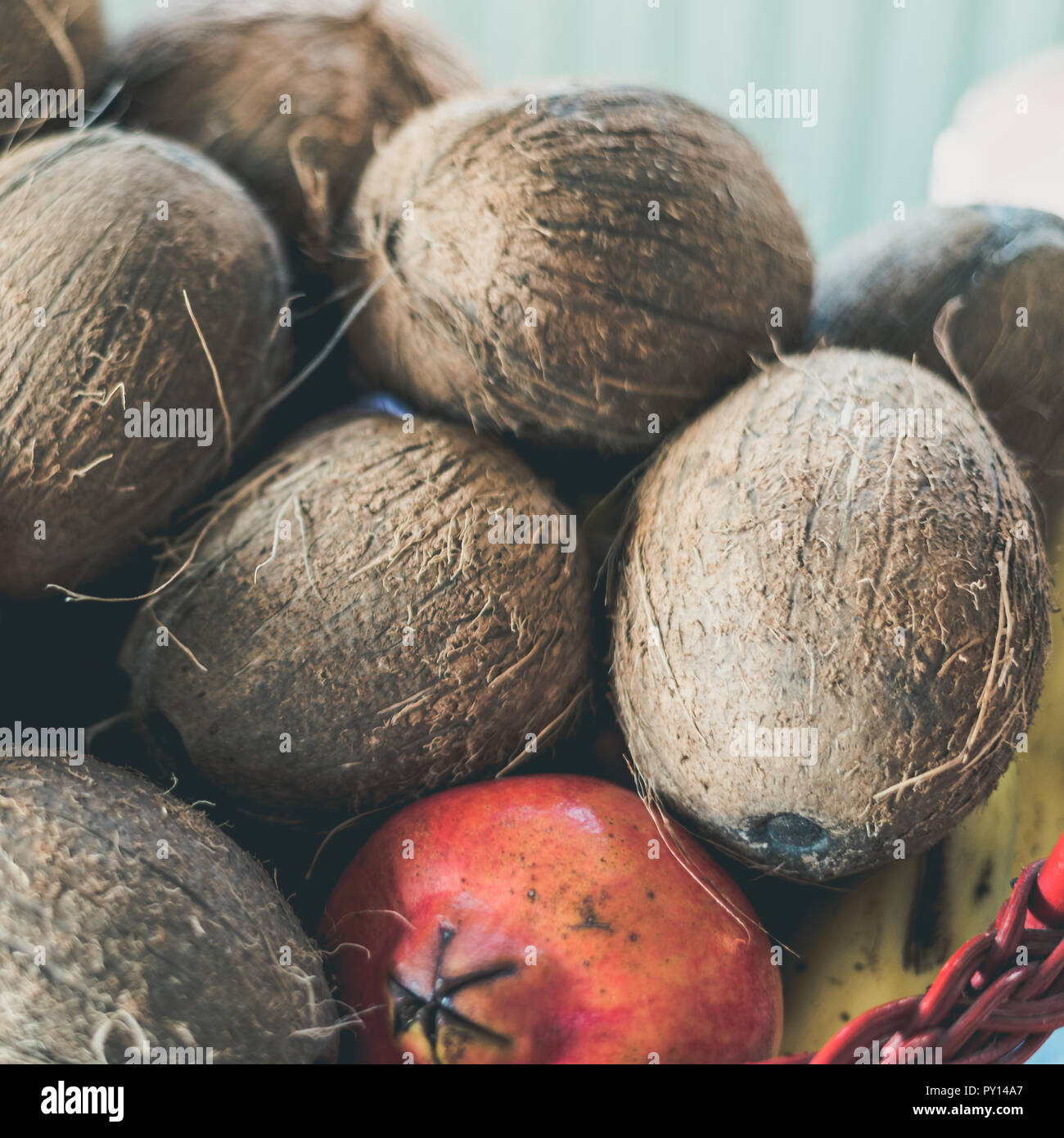 Group of coconuts and pomegranates in a basket for offerings to the ...