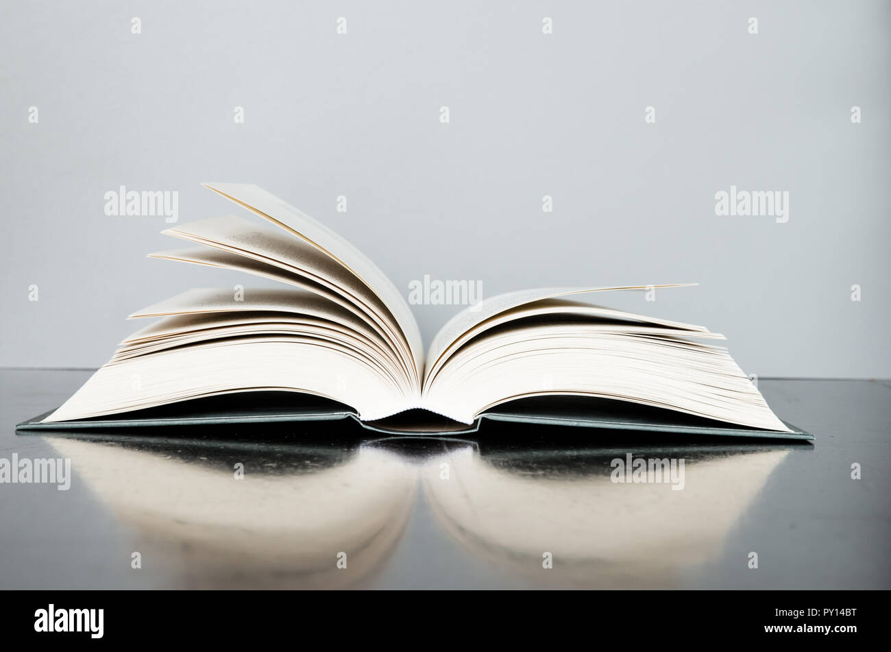 open book and its reflection on dark background Stock Photo - Alamy