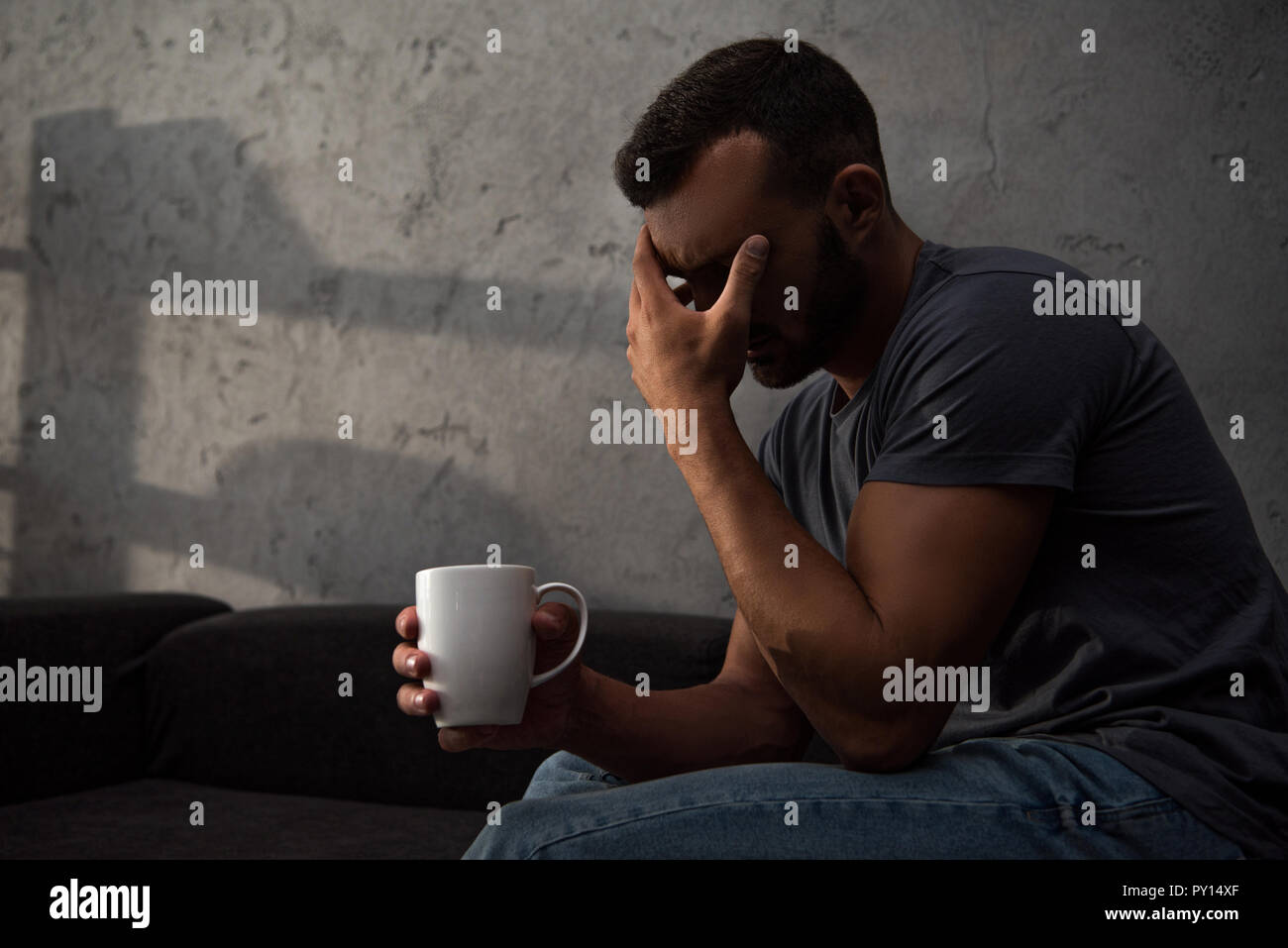 lonely crying man holding cup of coffee sitting at home Stock Photo - Alamy