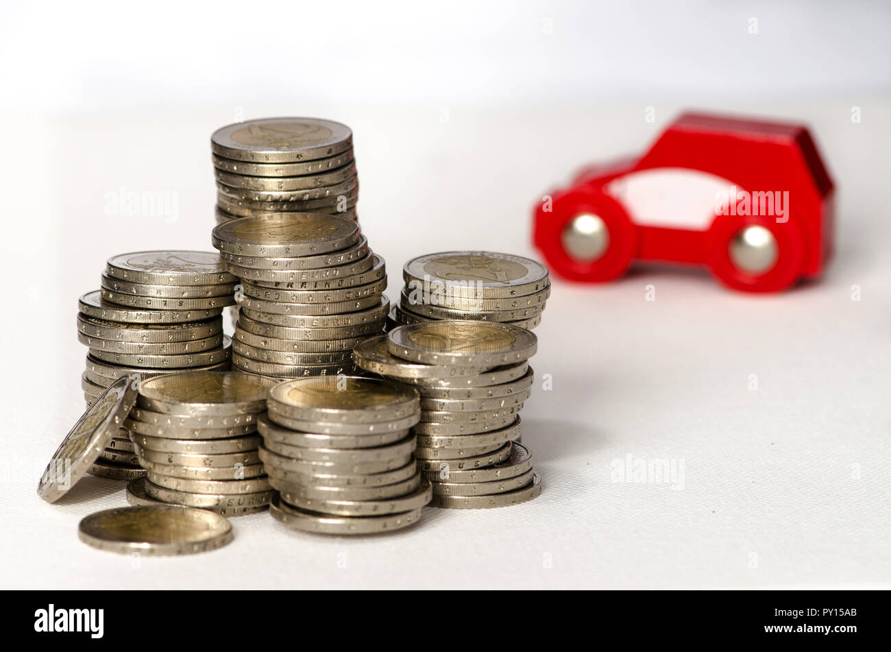 group of coins and car of white background Stock Photo - Alamy