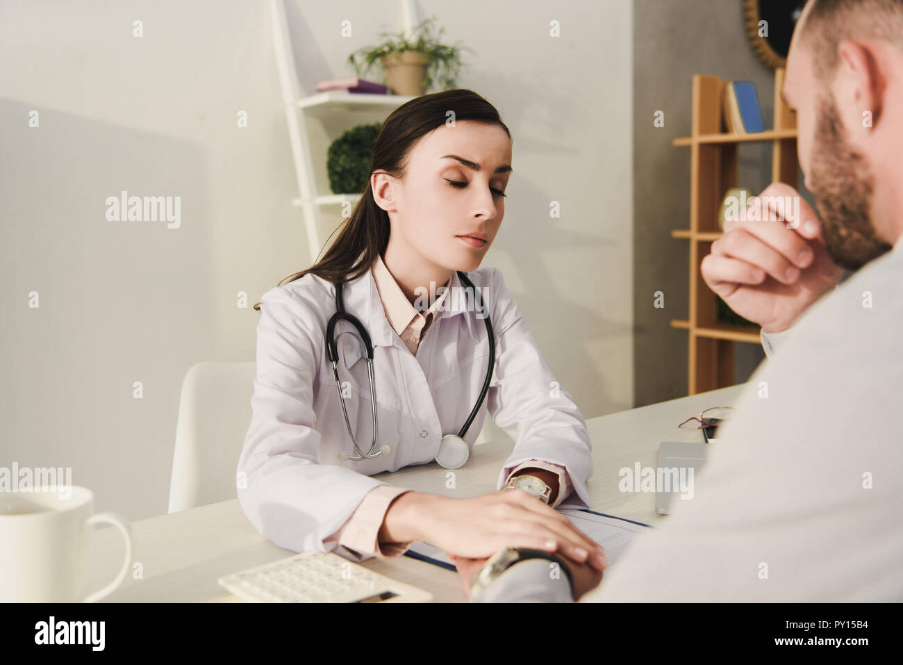 female doctor touching hand of client in medical office Stock Photo - Alamy