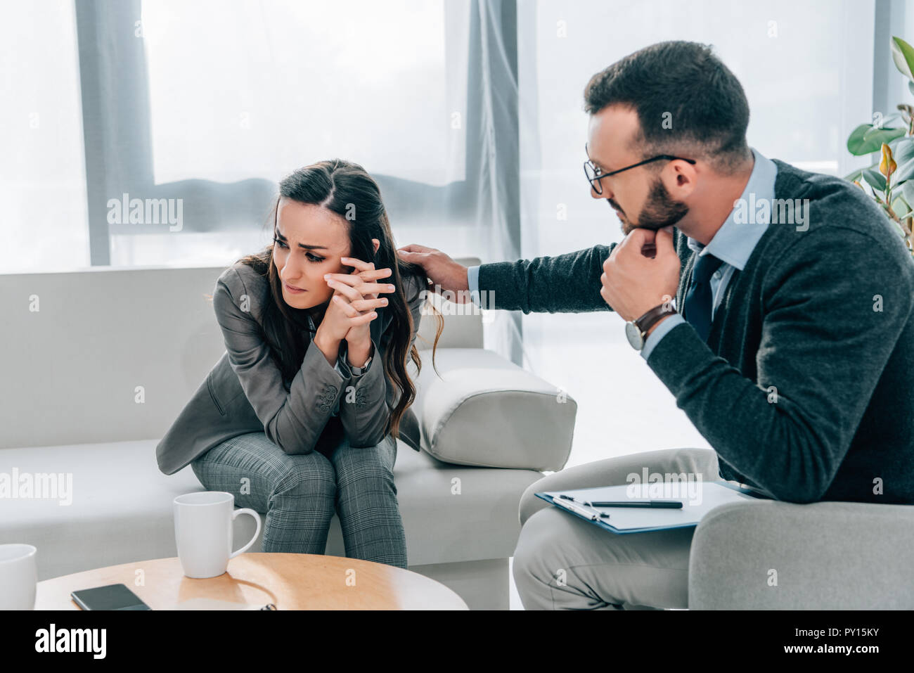 psychologist touching shoulder of crying patient in doctors office ...