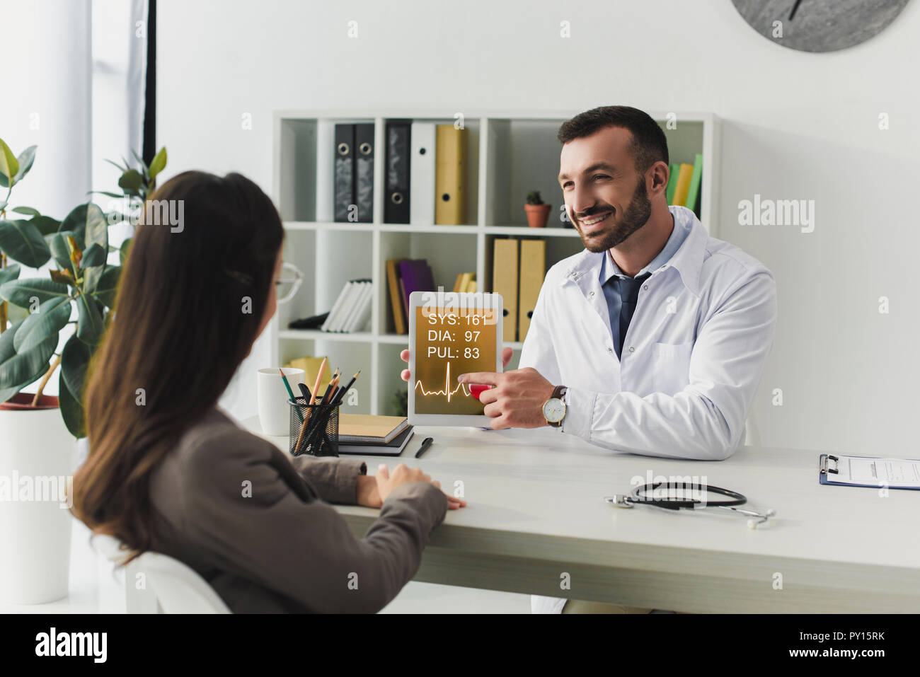 doctor showing patient tablet with pulse appliance in clinic Stock ...