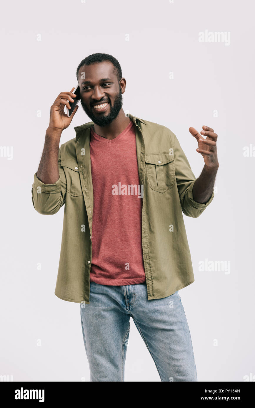 happy handsome african american man talking by smartphone and gesturing ...