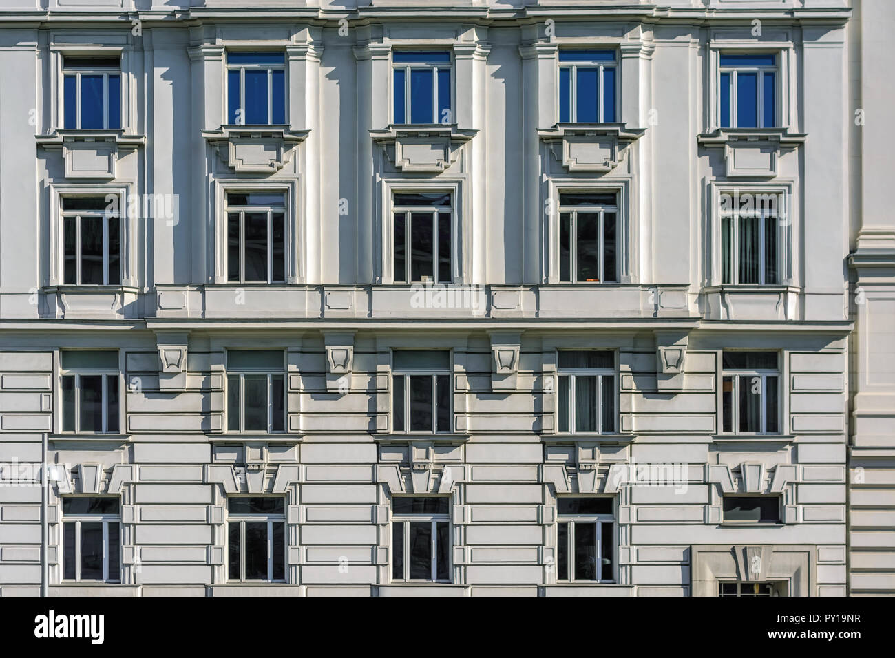 Rectangular windows on the facade of a gray building with a bas-relief ...