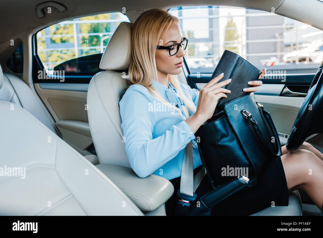 side view of businesswoman in eyeglasses checking wallet in car Stock ...