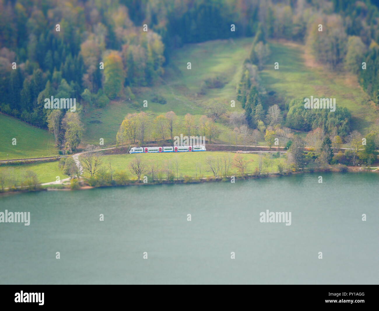 Tilt shift image of train in autumn landscape next to lake Stock Photo ...