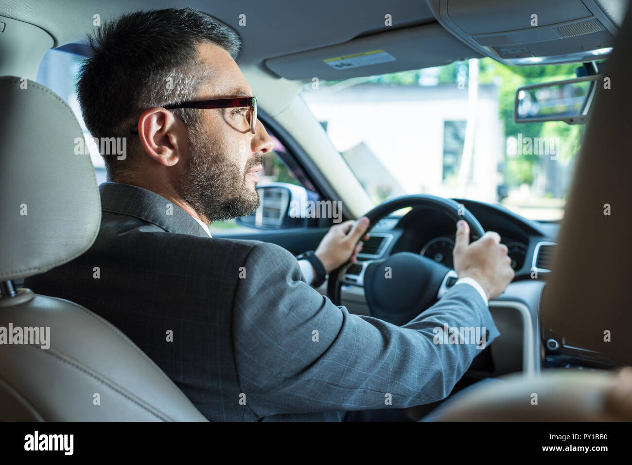 back view of businessman in suit and eyeglasses driving car alone Stock ...