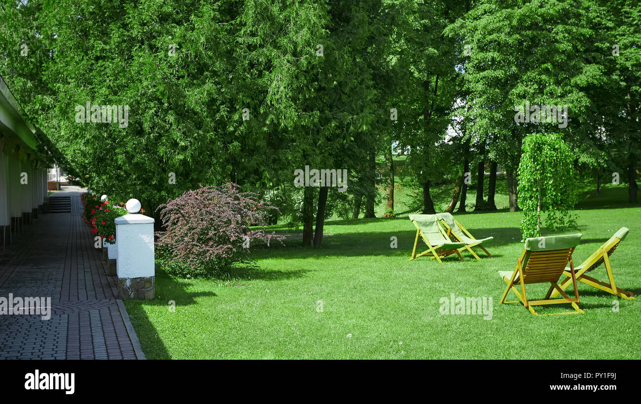 Rest chairs in the garden. Resort concept Stock Photo - Alamy