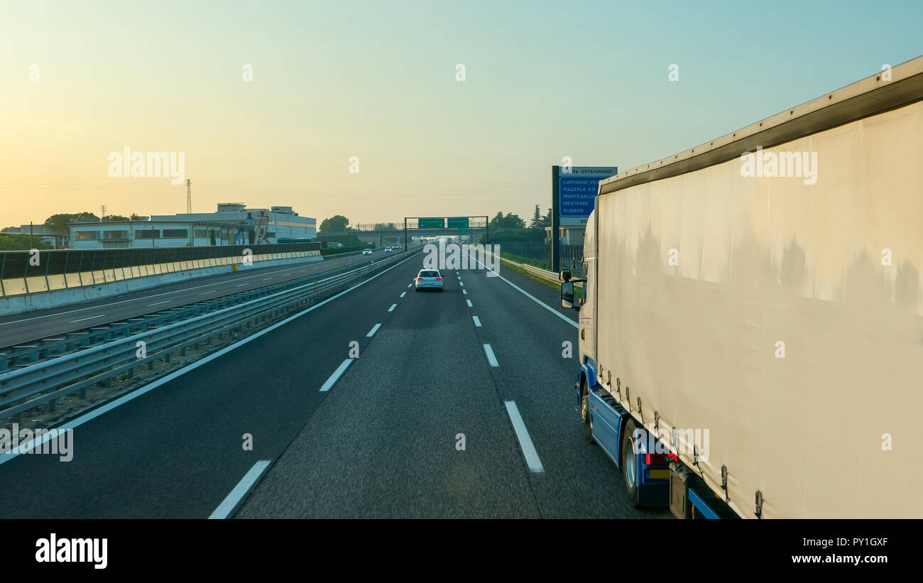 White truck driving motorway at sunrise, transportation background ...
