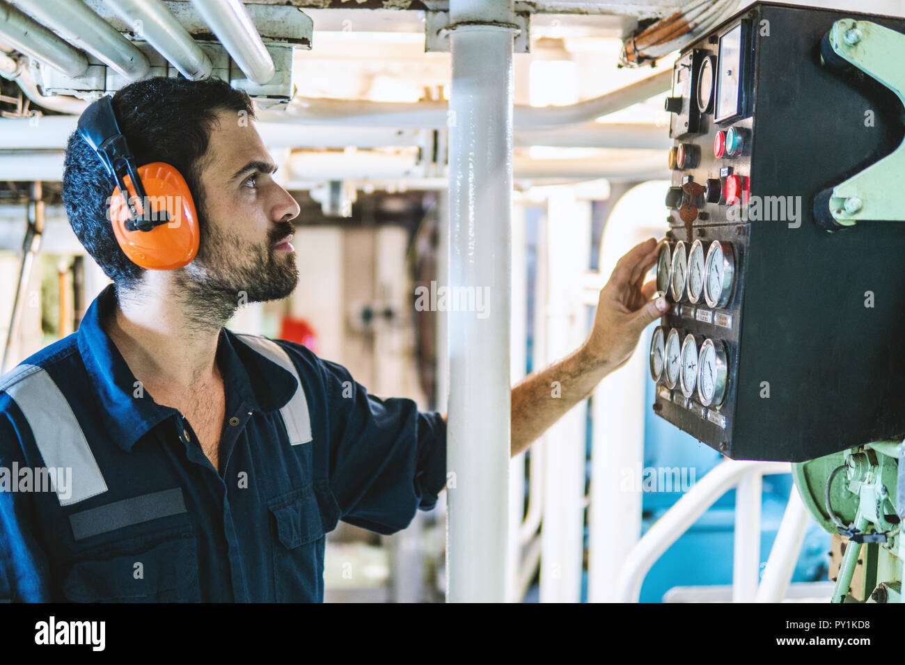 Marine engineer officer working in engine room Stock Photo - Alamy