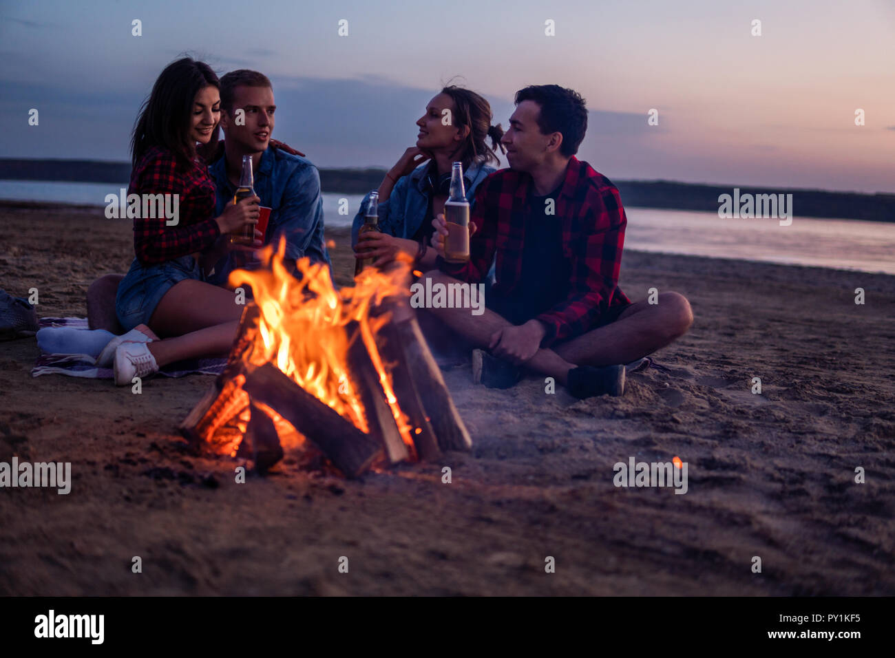 young friends have picnic with bonfire on the beach Stock Photo - Alamy