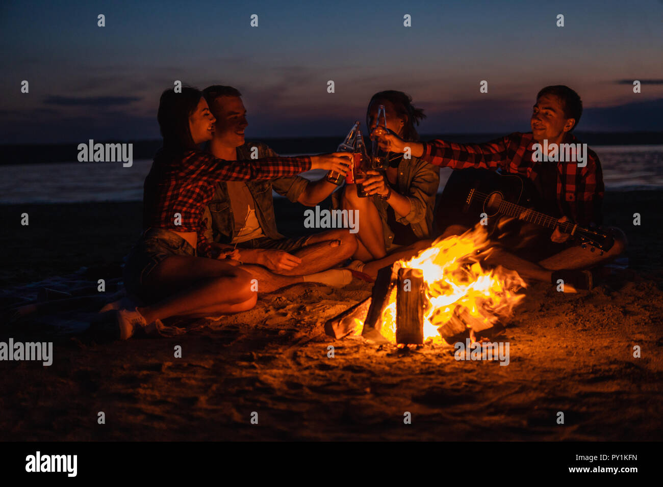 young friends have picnic with bonfire on the beach Stock Photo - Alamy