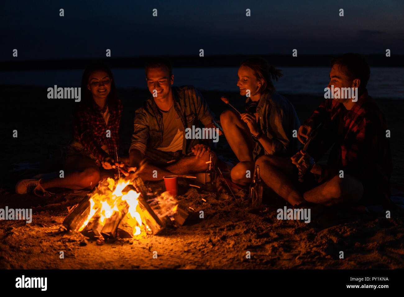 young friends have picnic with bonfire on the beach Stock Photo - Alamy