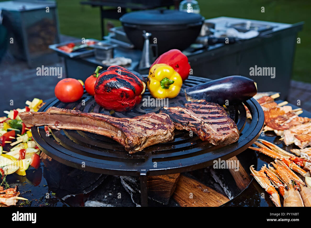 Tomahawk rib beef steak and T-bone on hot black grill Stock Photo - Alamy