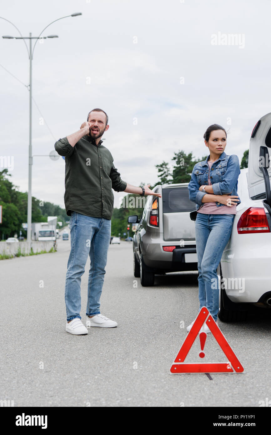 angry and upset drivers standing on road after car accident Stock Photo ...