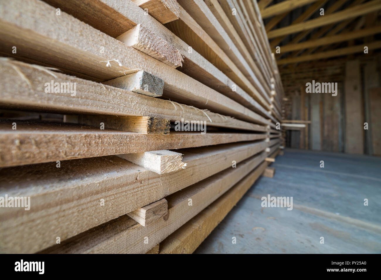 Perspective view of neatly piled long stack of natural uneven rough ...