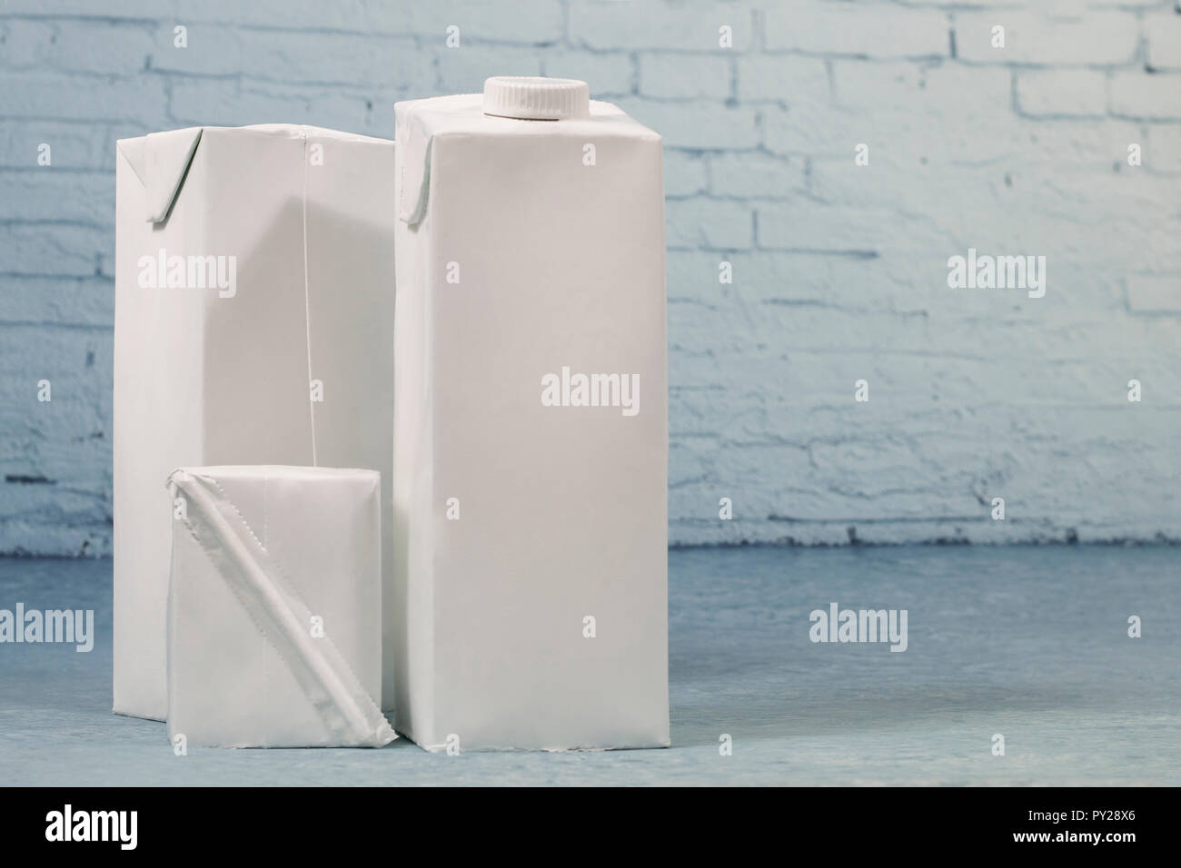Mix of milk packages isolated on a blue brick background Stock Photo ...