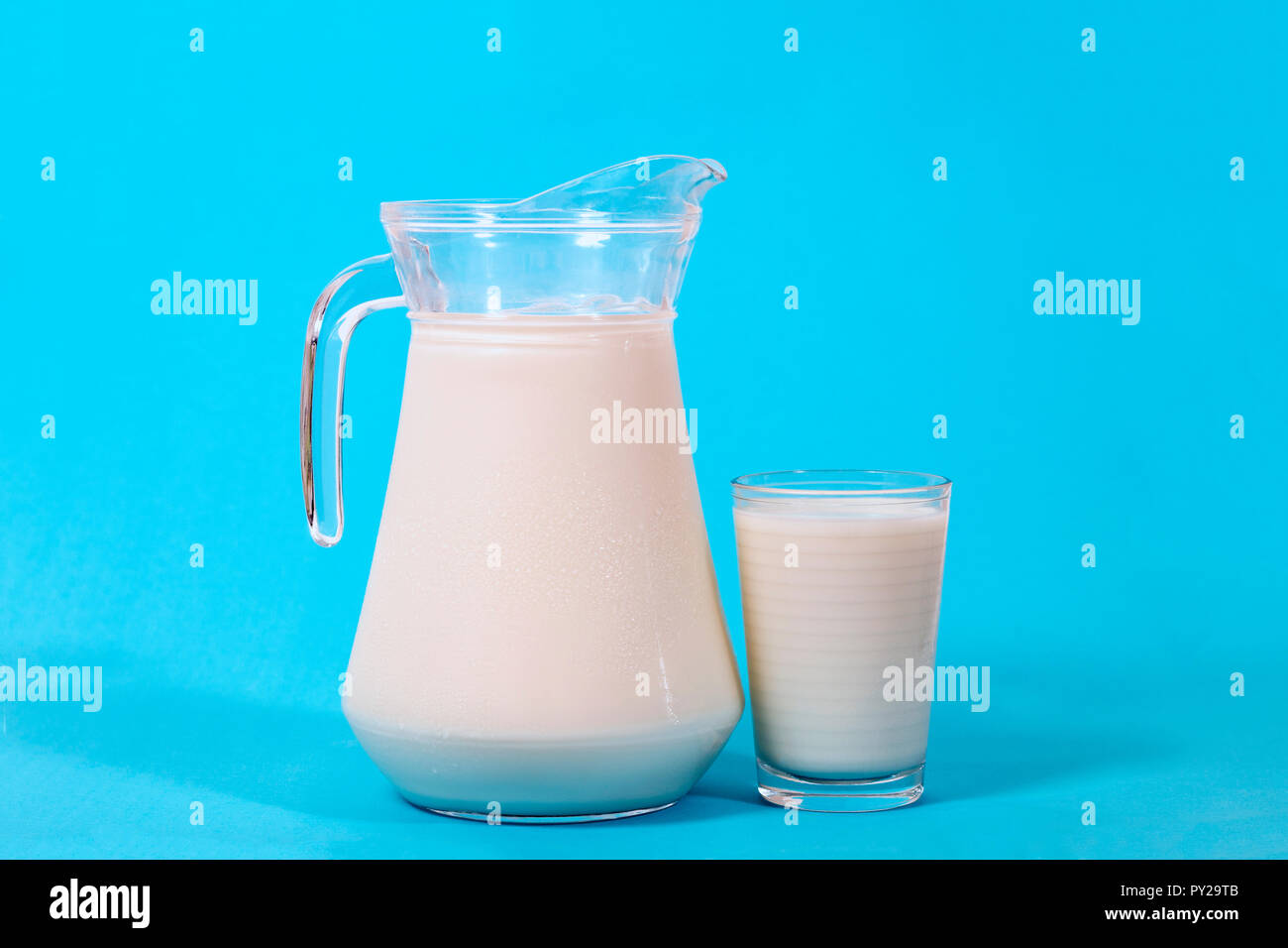 full glass jar and glass of milk isolated on a blue background Stock ...