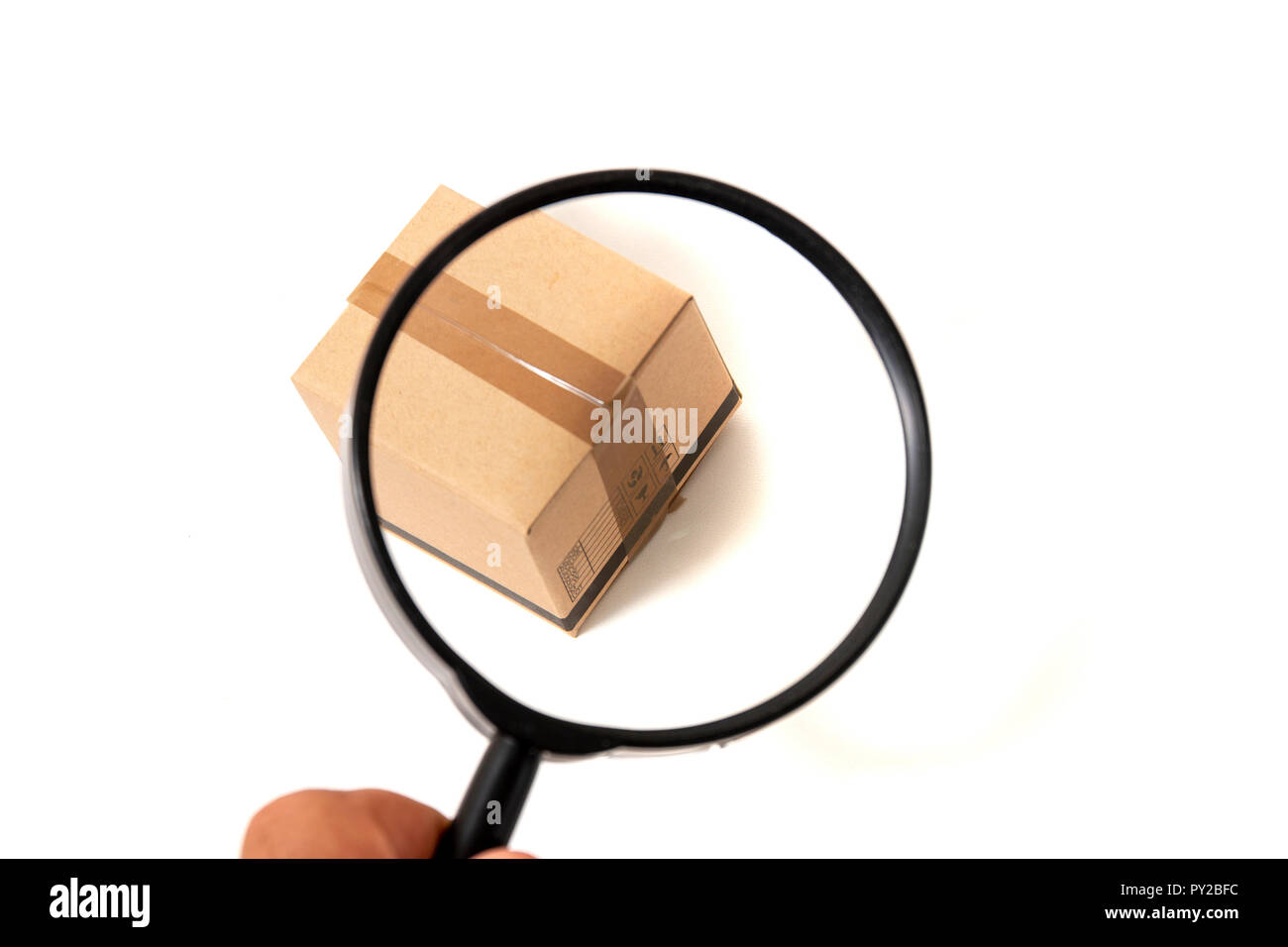 magnifying glass inspecting a cardboard box isolated over a white ...