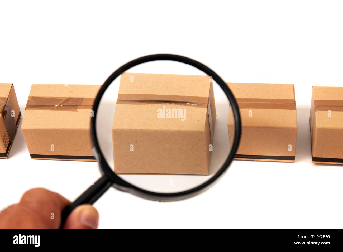 magnifying glass inspecting a cardboard box isolated over a white ...