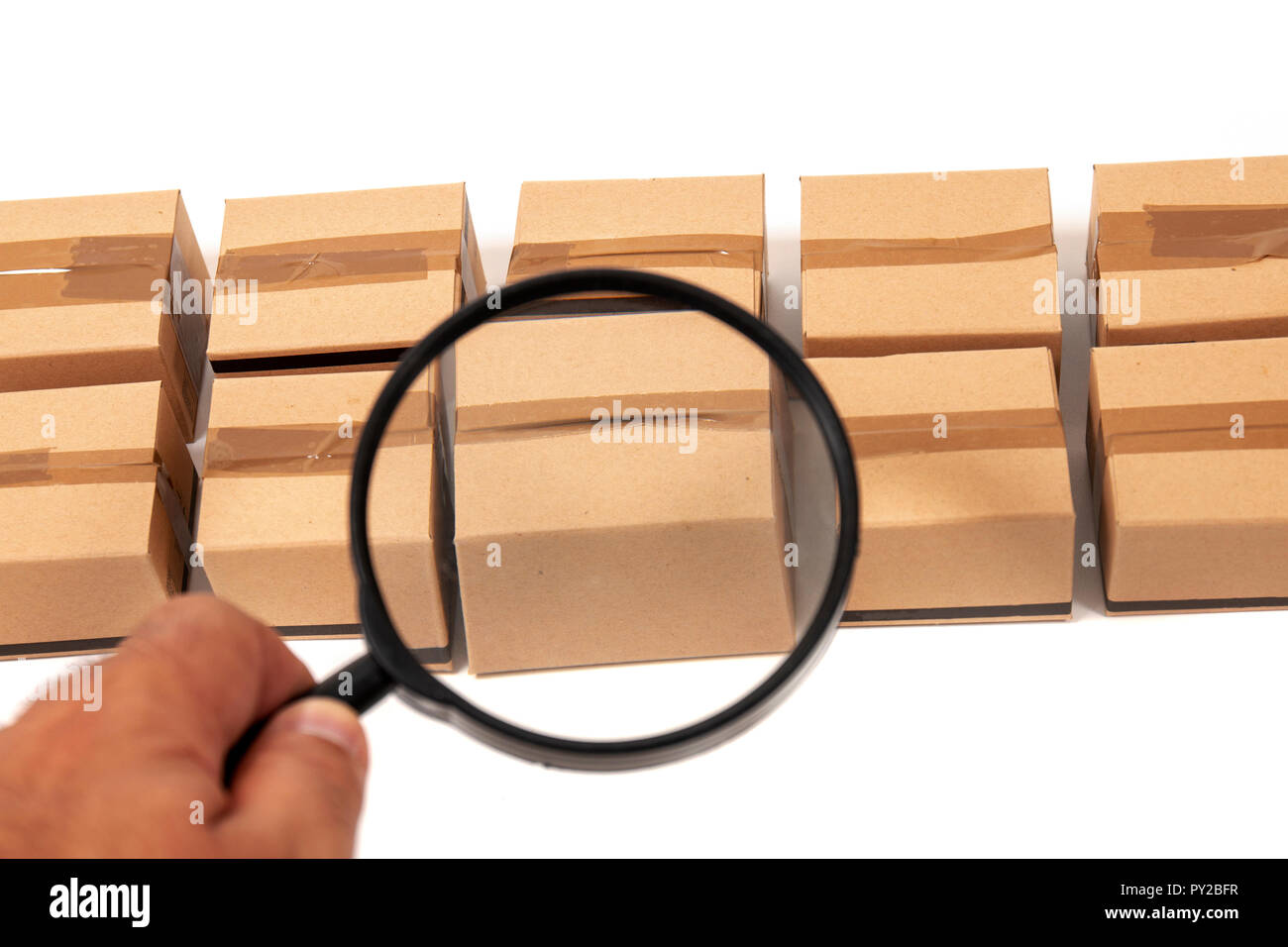 magnifying glass inspecting a cardboard box isolated over a white ...