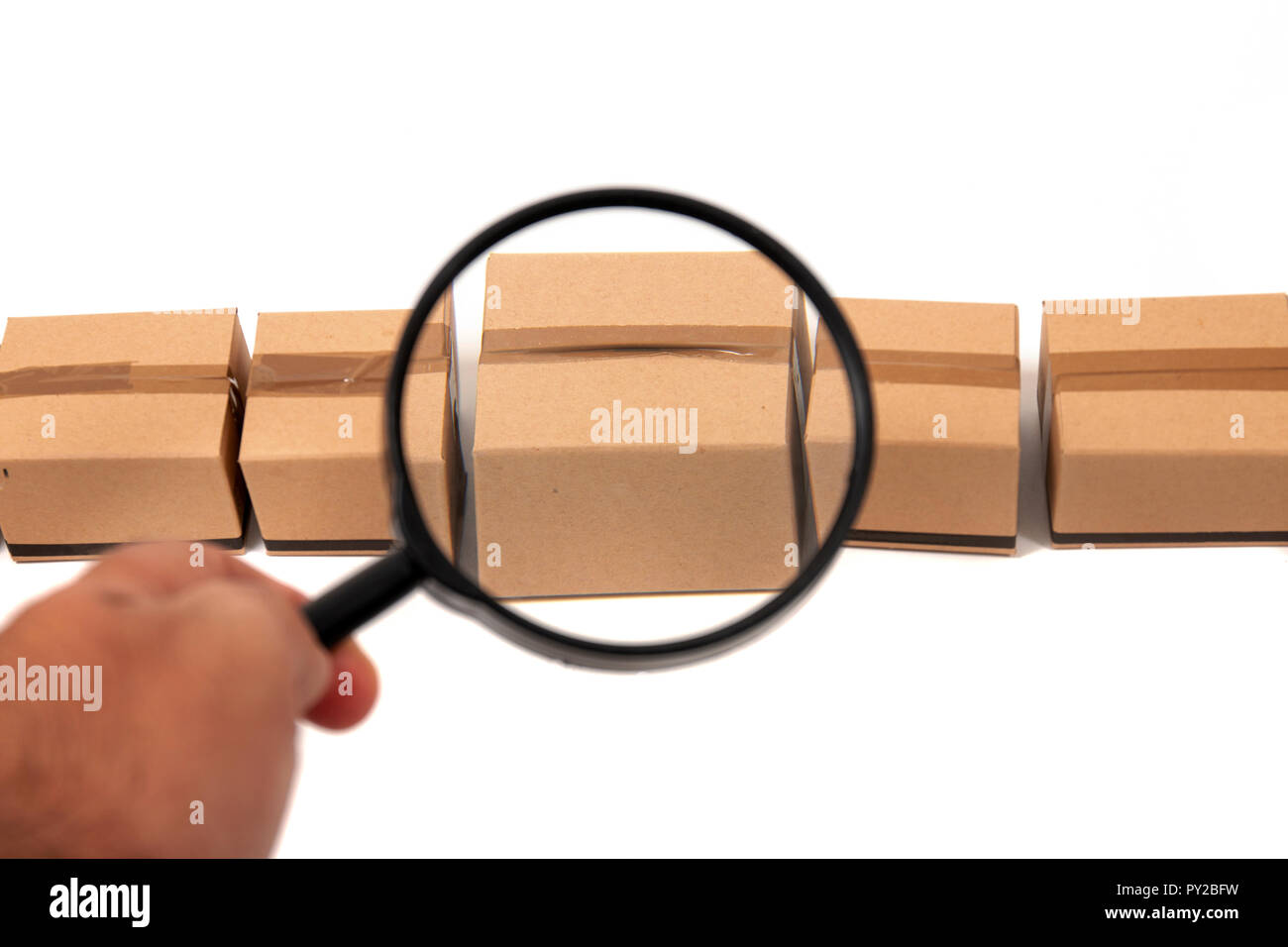 magnifying glass inspecting a cardboard box isolated over a white ...