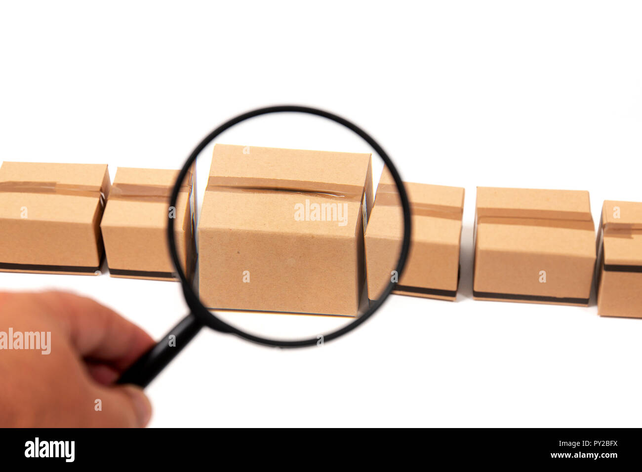 magnifying glass inspecting a cardboard box isolated over a white ...