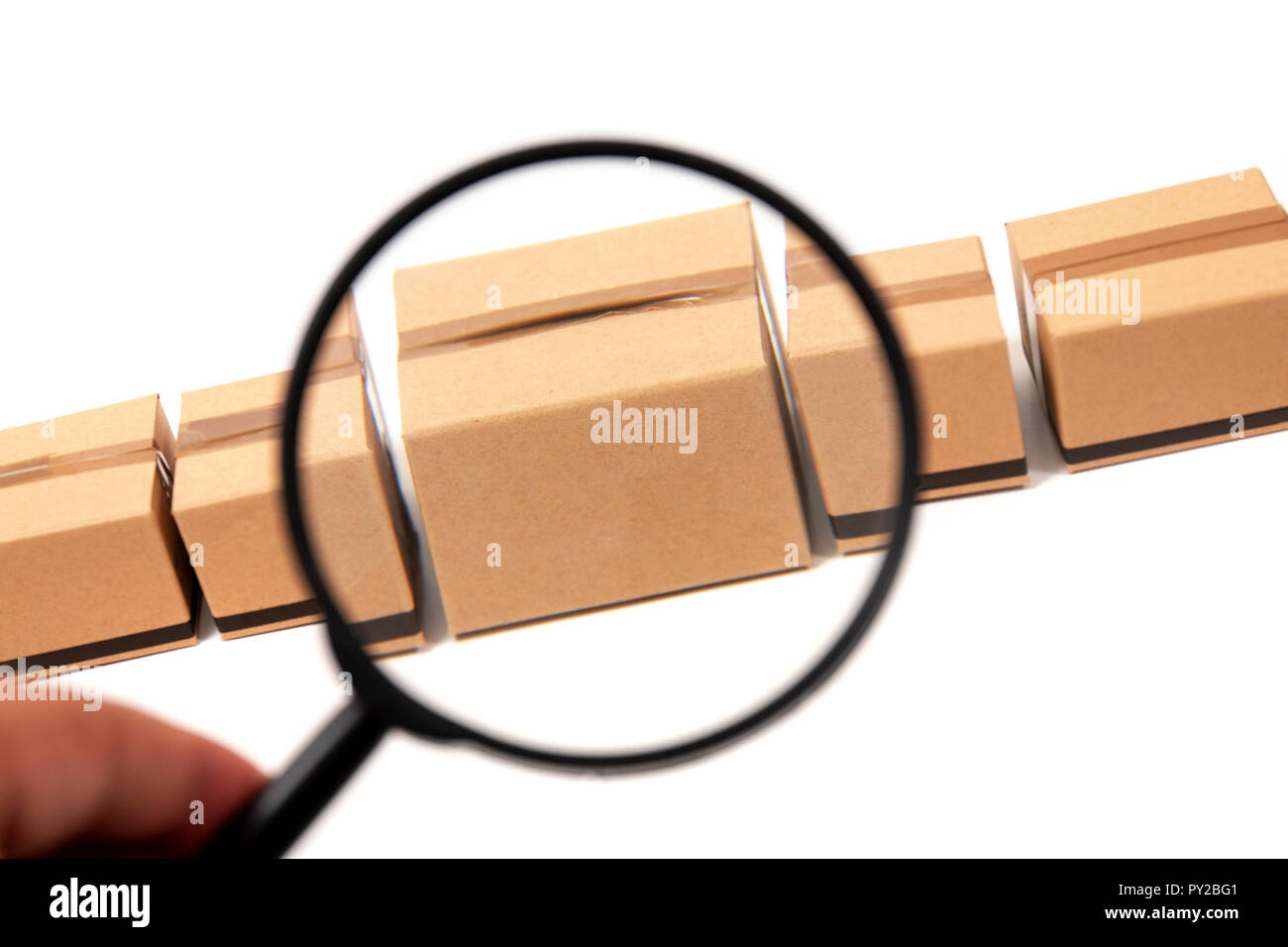 magnifying glass inspecting a cardboard box isolated over a white ...