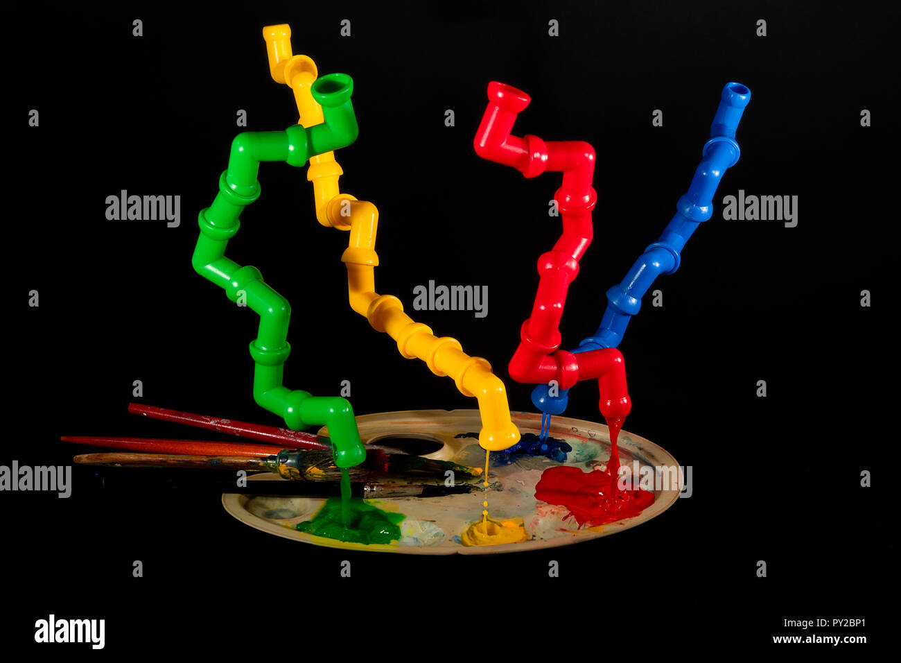 Acrylic paint pouring out of a pipe onto a paint palette Stock Photo ...