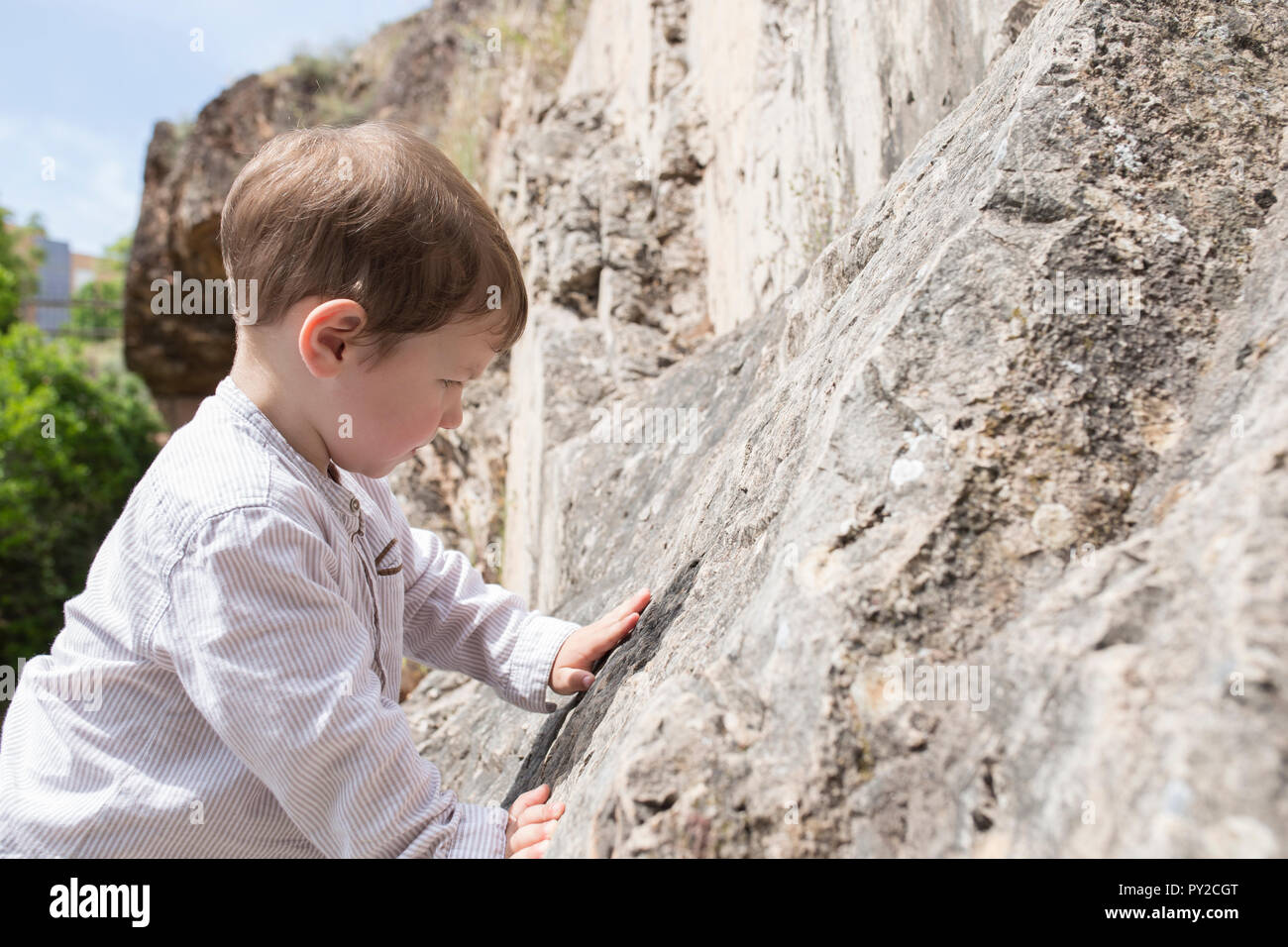 3 years old child touching the rock surface. Getting acquainted with ...