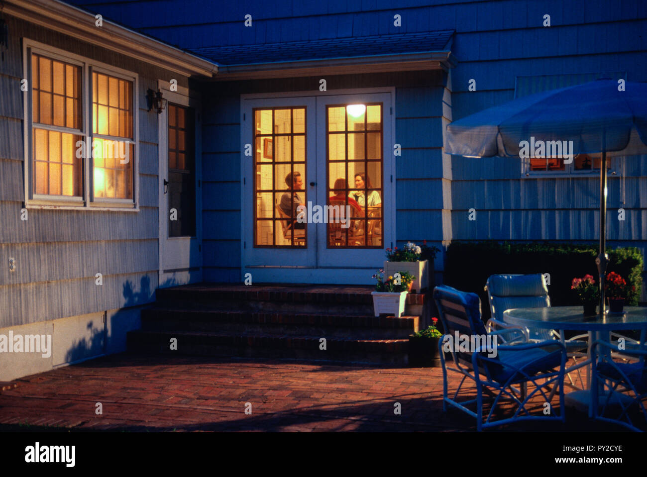 Family Inside Suburban House Seen through French Doors from Patio, USA ...