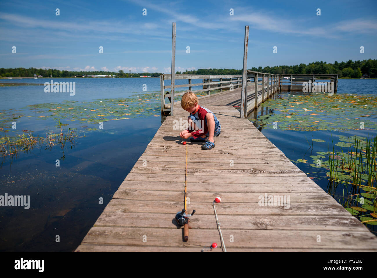 Boy sitting on jetty hi-res stock photography and images - Alamy