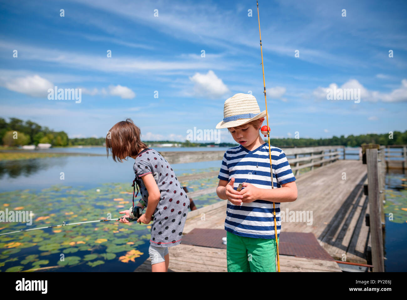 Two children fishing on a dock in the summer, United States Stock Photo ...