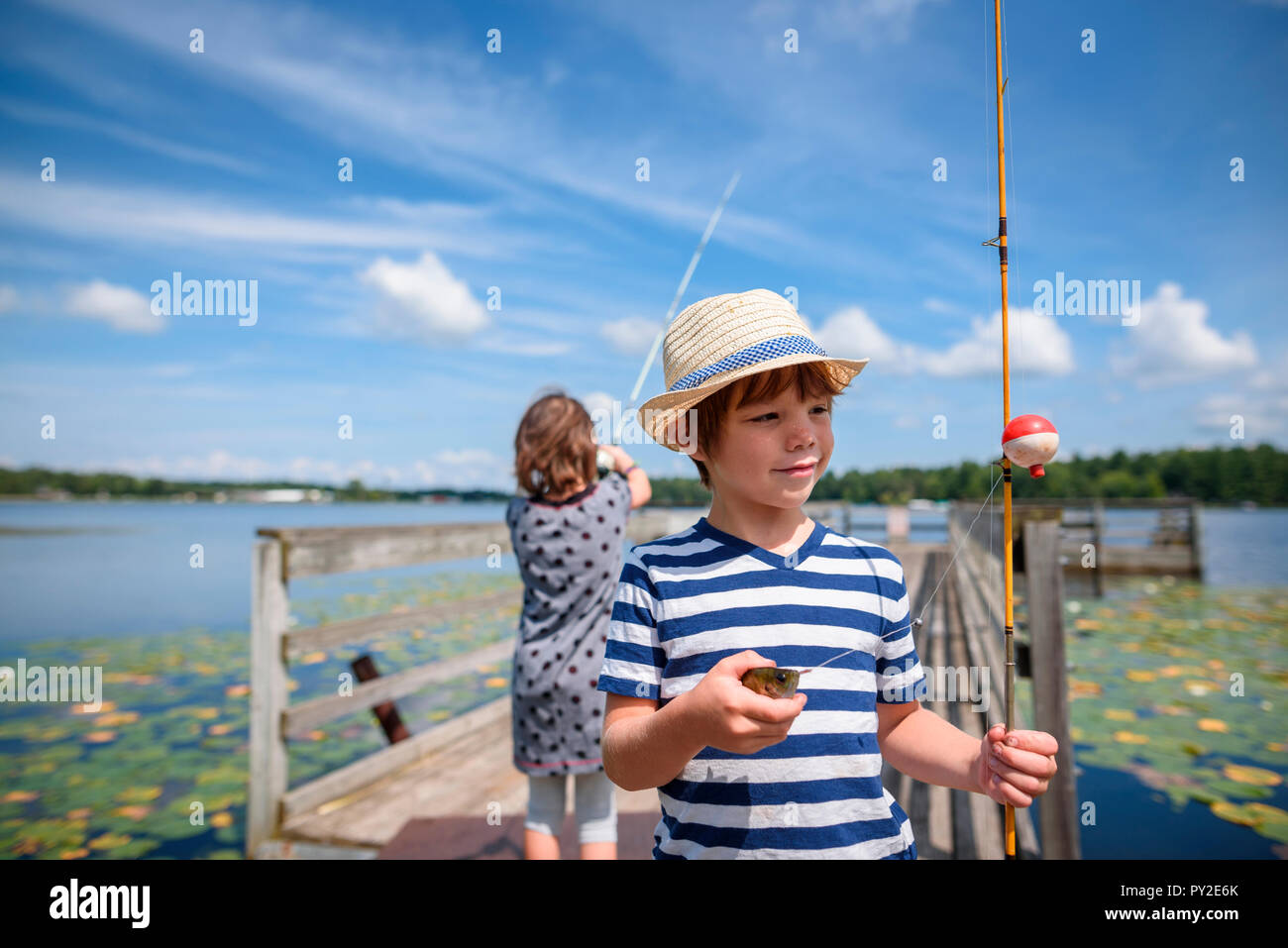 Two children fishing on a dock in the summer, United States Stock Photo ...