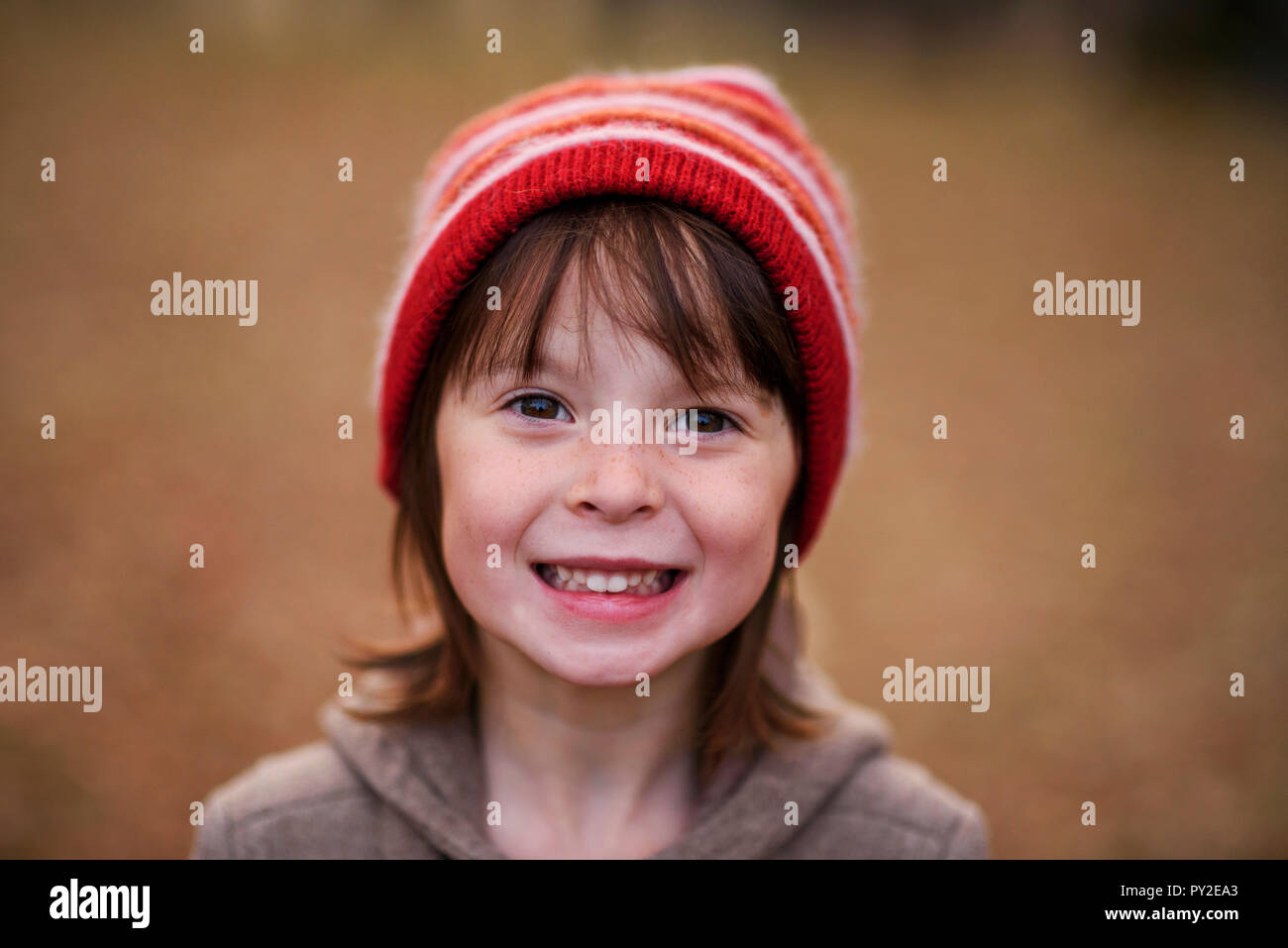 Portrait of a smiling girl wearing a woolly hat Stock Photo - Alamy