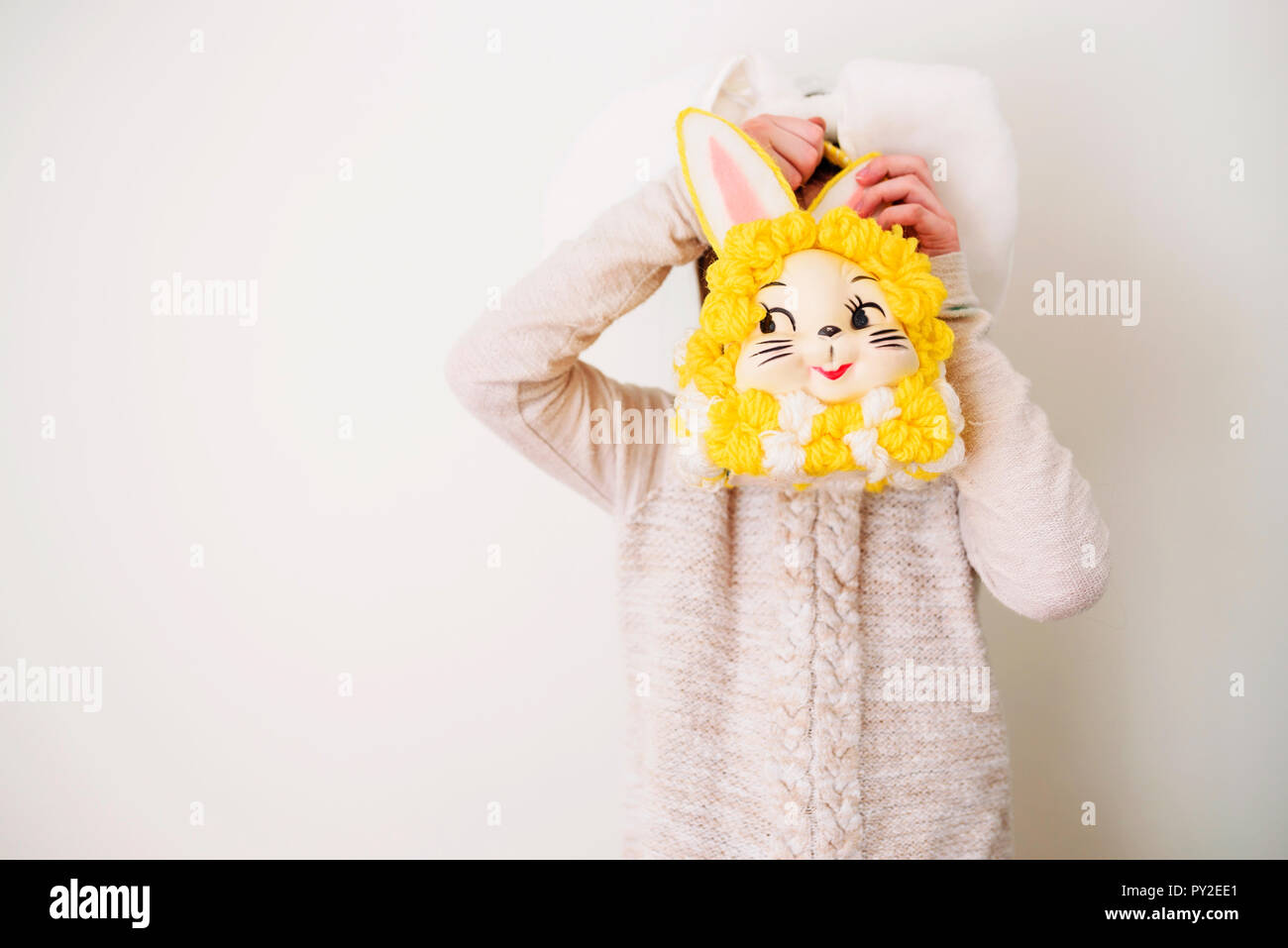 Girl wearing bunny ears holding a bunny handbag in front of her face ...