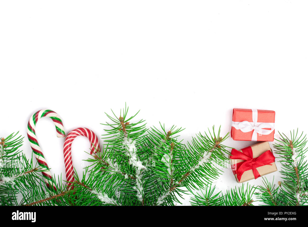 Christmas Frame of Fir tree branch with candy canes and snow isolated ...